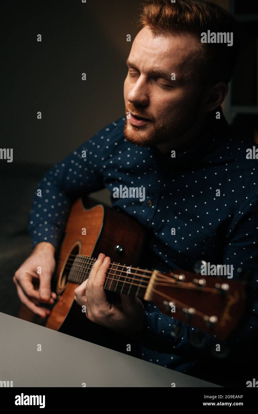 Vertical portrait of guitarist singer male playing acoustic guitar and ...