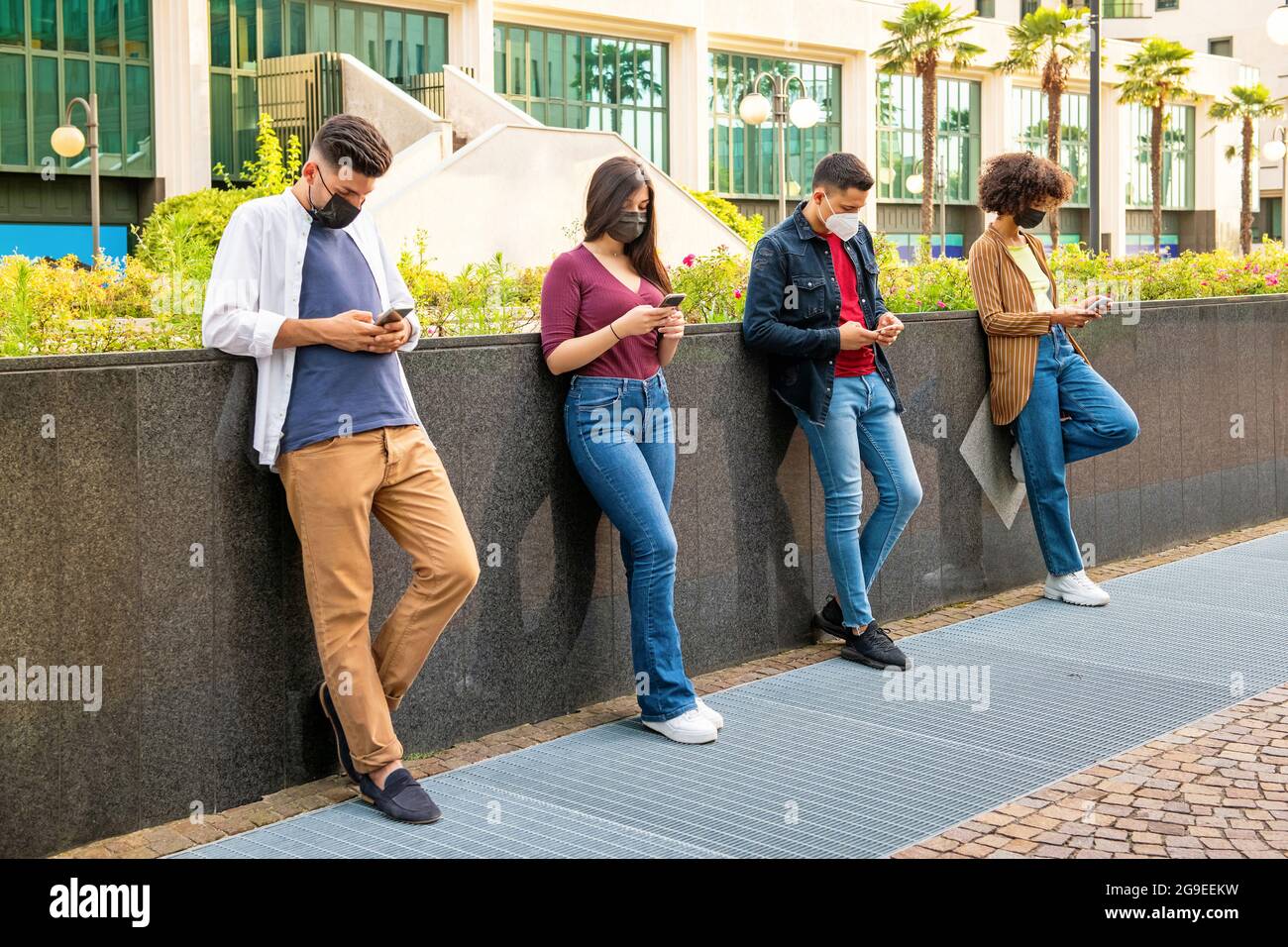 Line of friends ignoring each other to text on their mobile phones as ...