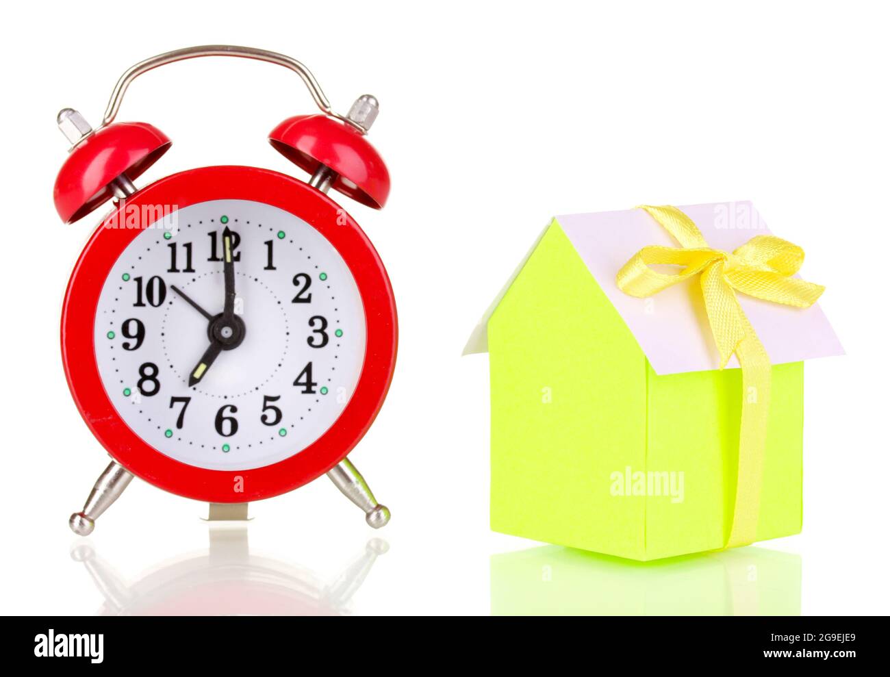 Small house with alarm clock isolated on white Stock Photo - Alamy