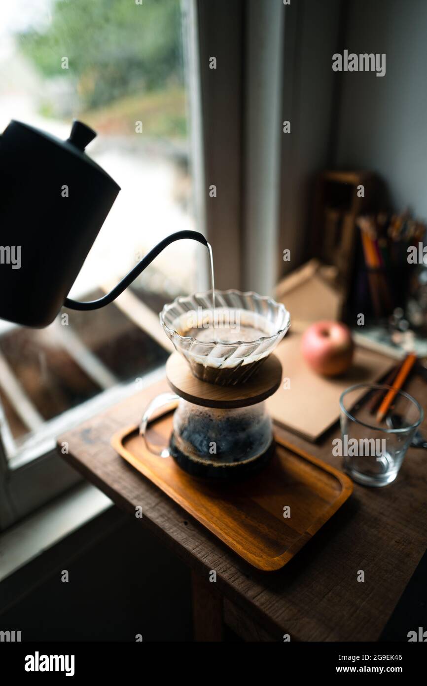 hot water into coffee dripper above glass jar Stock Photo - Alamy