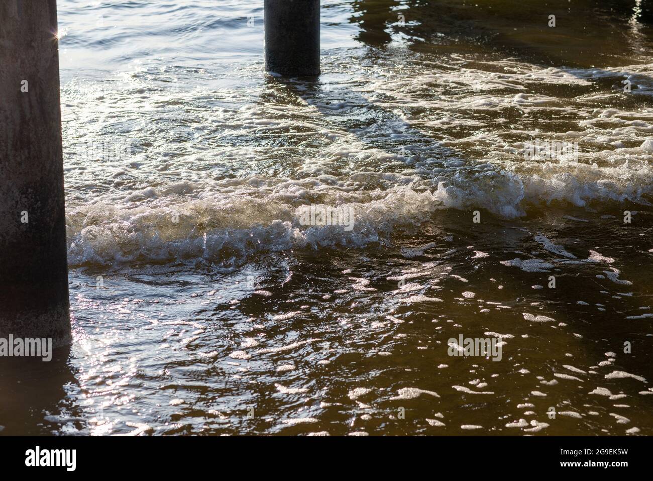 Columnar bridge piers at sunset.View under the bridge into sea with ...