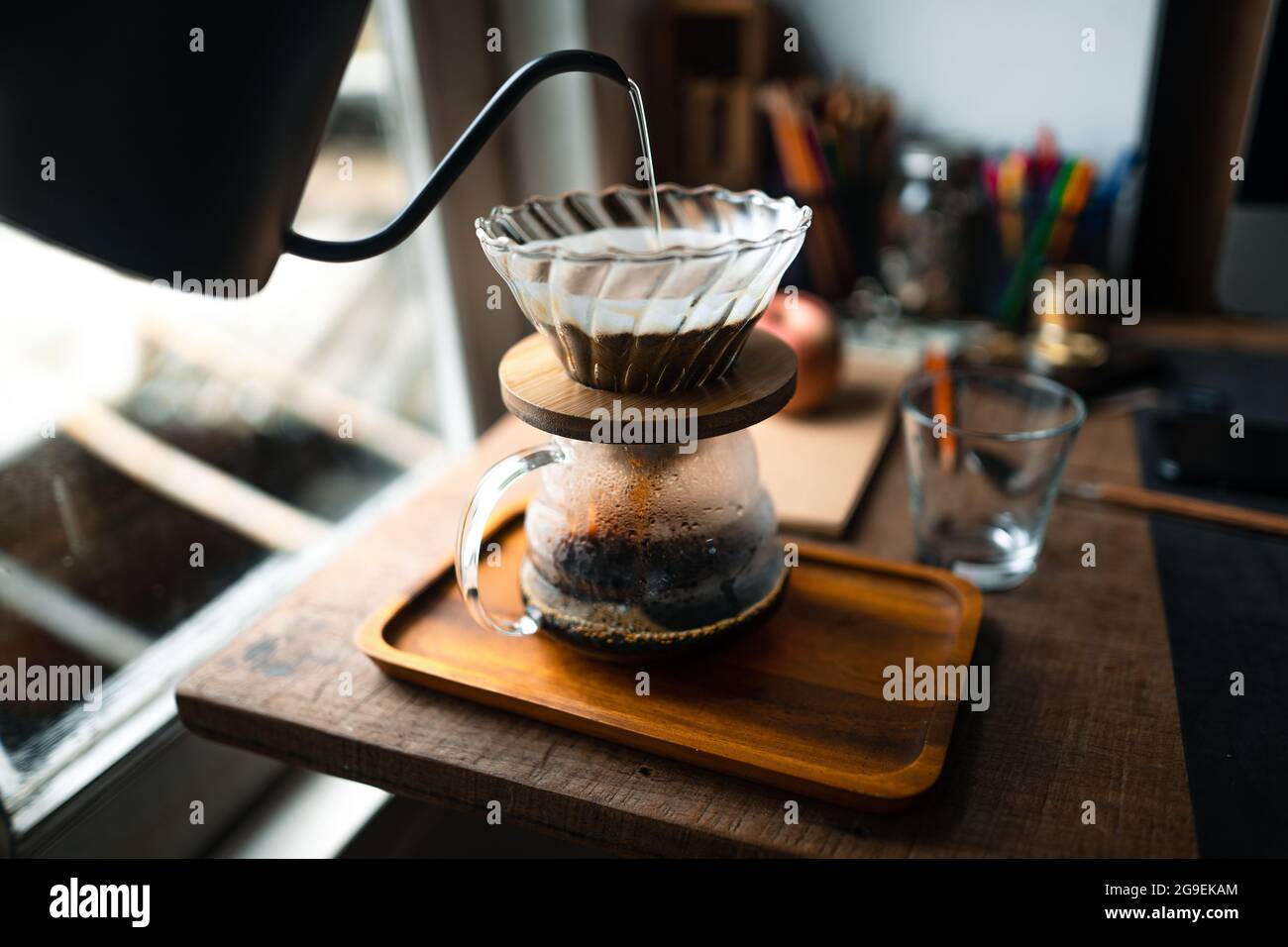 hot water into coffee dripper above glass jar Stock Photo - Alamy