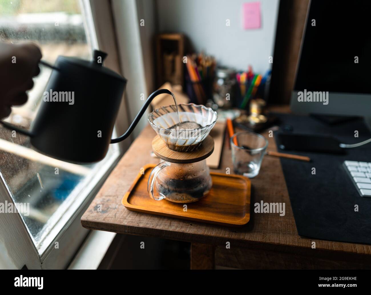 hot water into coffee dripper above glass jar Stock Photo - Alamy