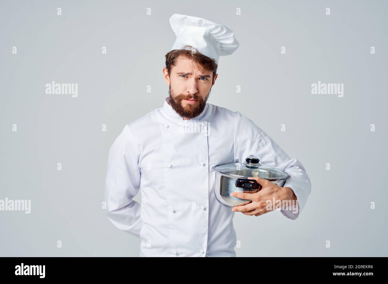 professional chef with pan in hand cooking food kitchen light ...