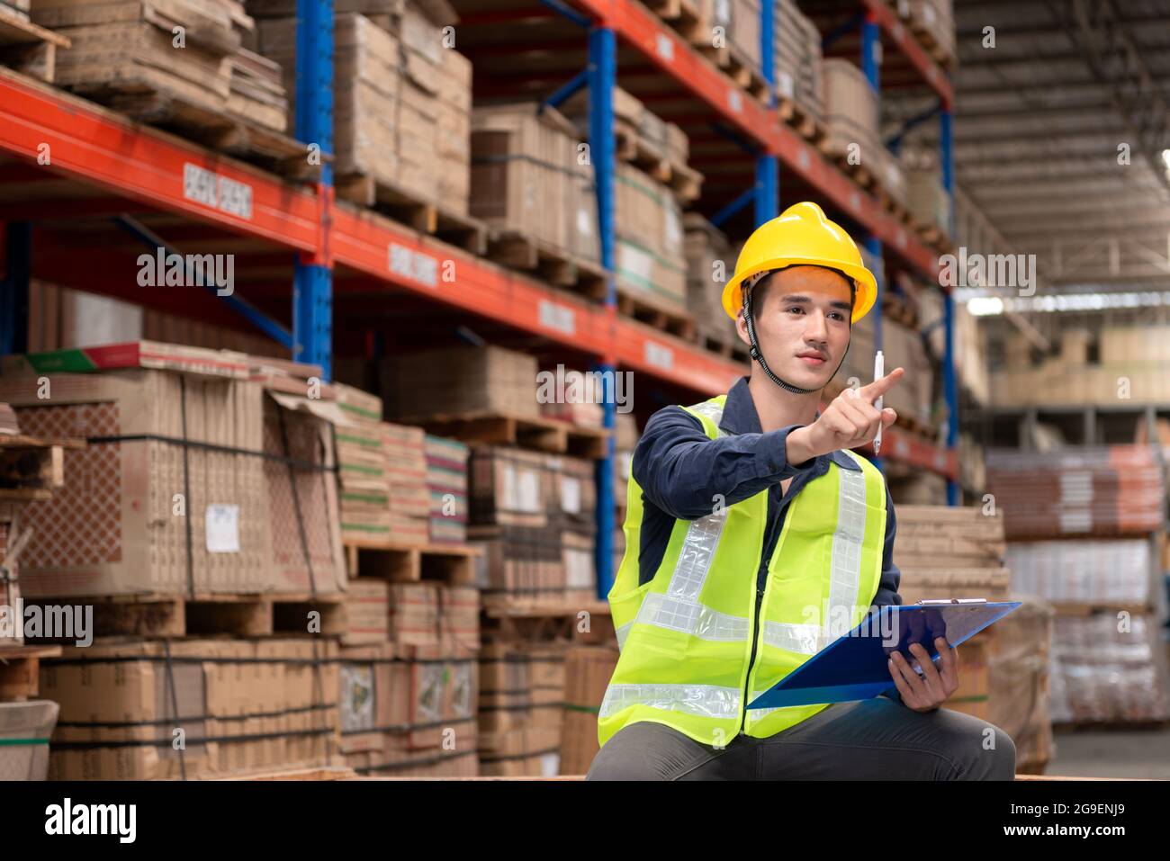Warehouse worker checking packages on shelf in a large store Stock ...