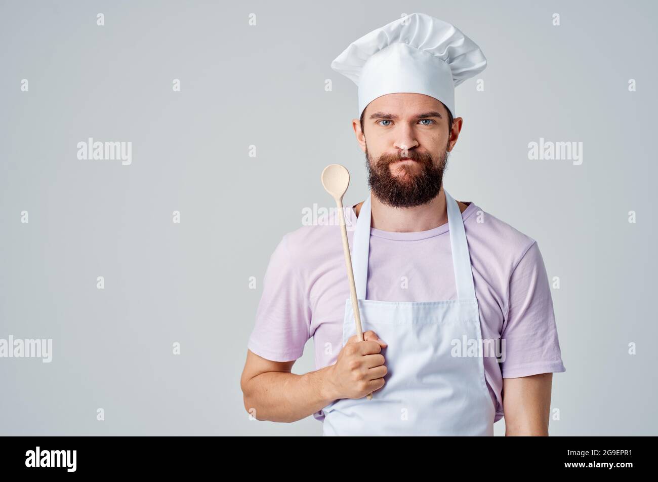emotional bearded chef with a cap on his head holds a spoon in his ...