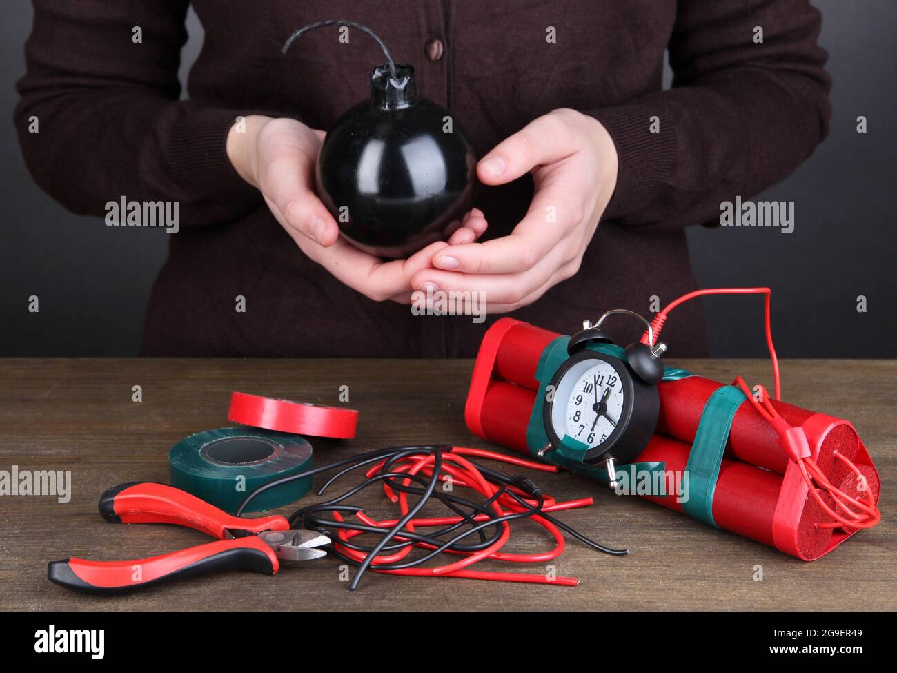 Human makes timebomb on wooden table on black background Stock Photo ...