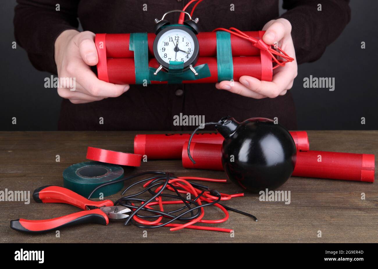 Human makes timebomb on wooden table on black background Stock Photo ...