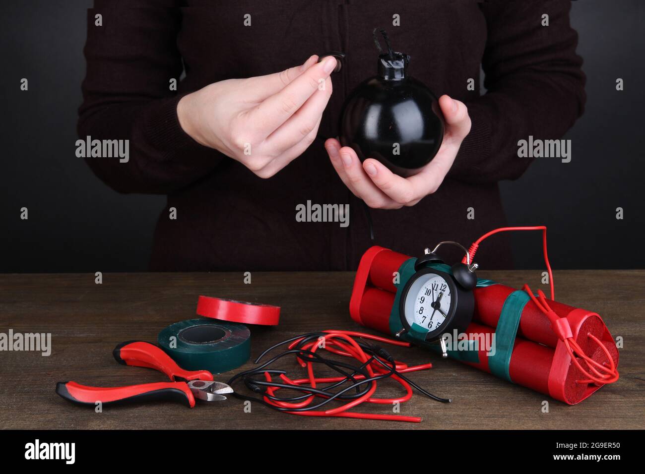 Human makes timebomb on wooden table on black background Stock Photo ...