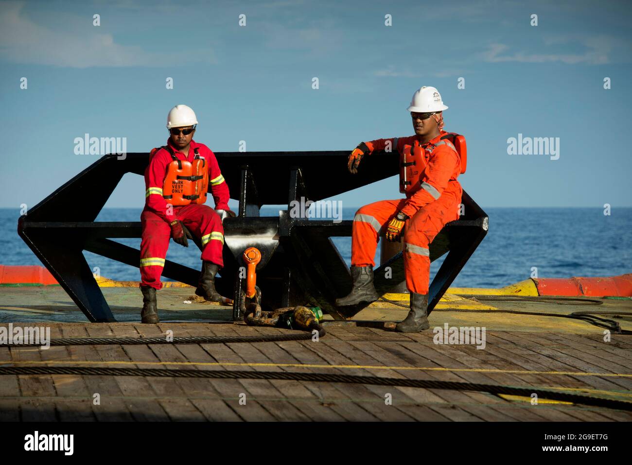 marine crew working on deck during anchor handling operation at sea ...