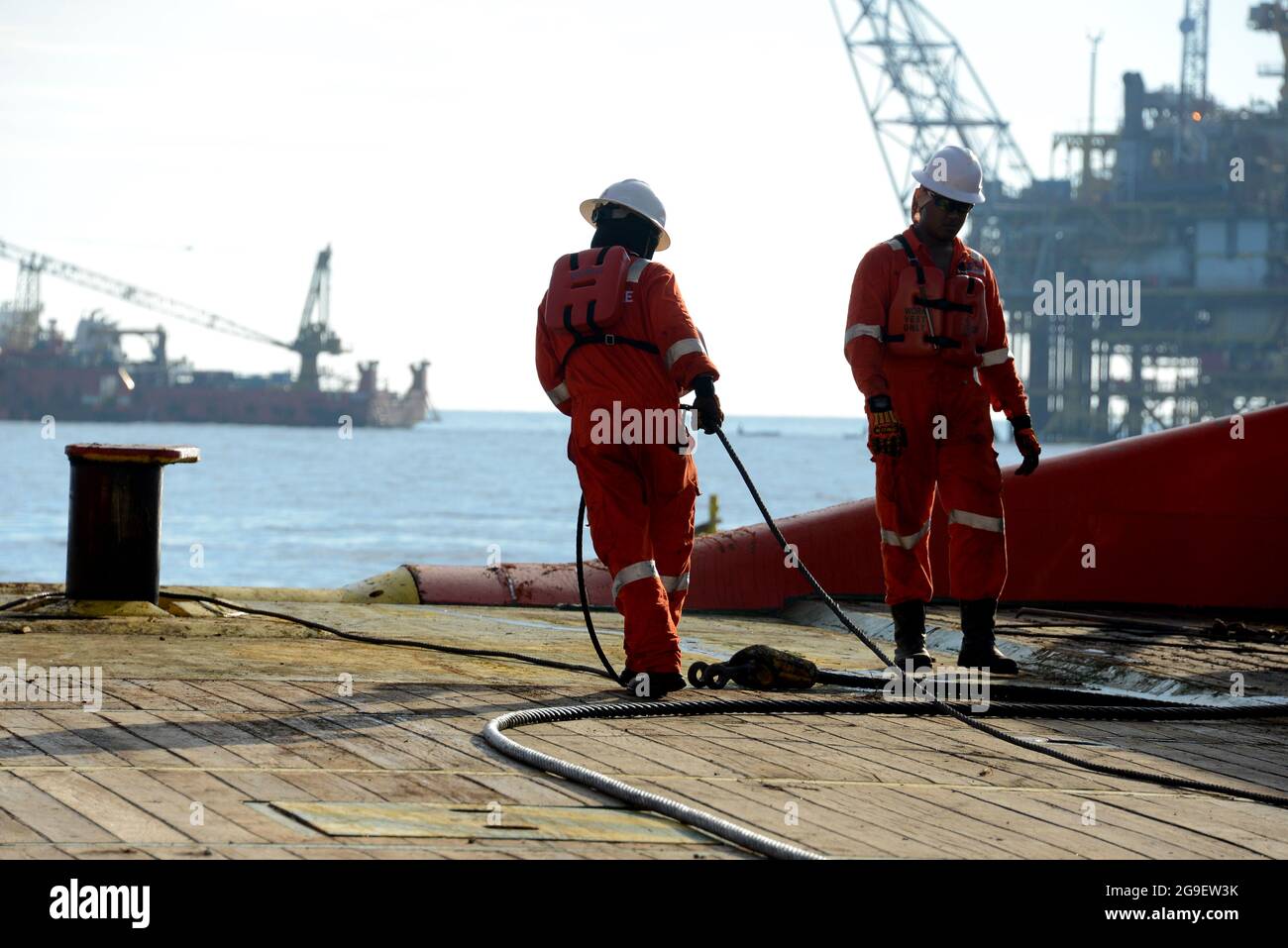marine crew working on deck during anchor handling operation at sea ...
