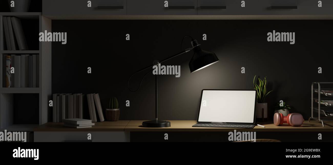 Work space at night with open laptop and light from table lamp, late ...