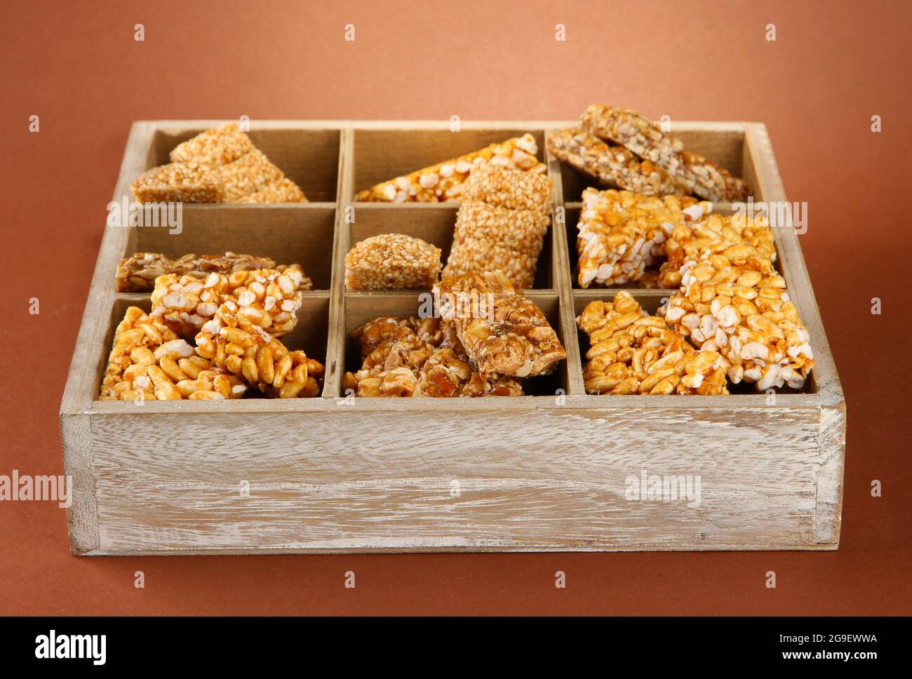 tasty sweets (kozinaki)in wooden crate on brown background Stock Photo ...