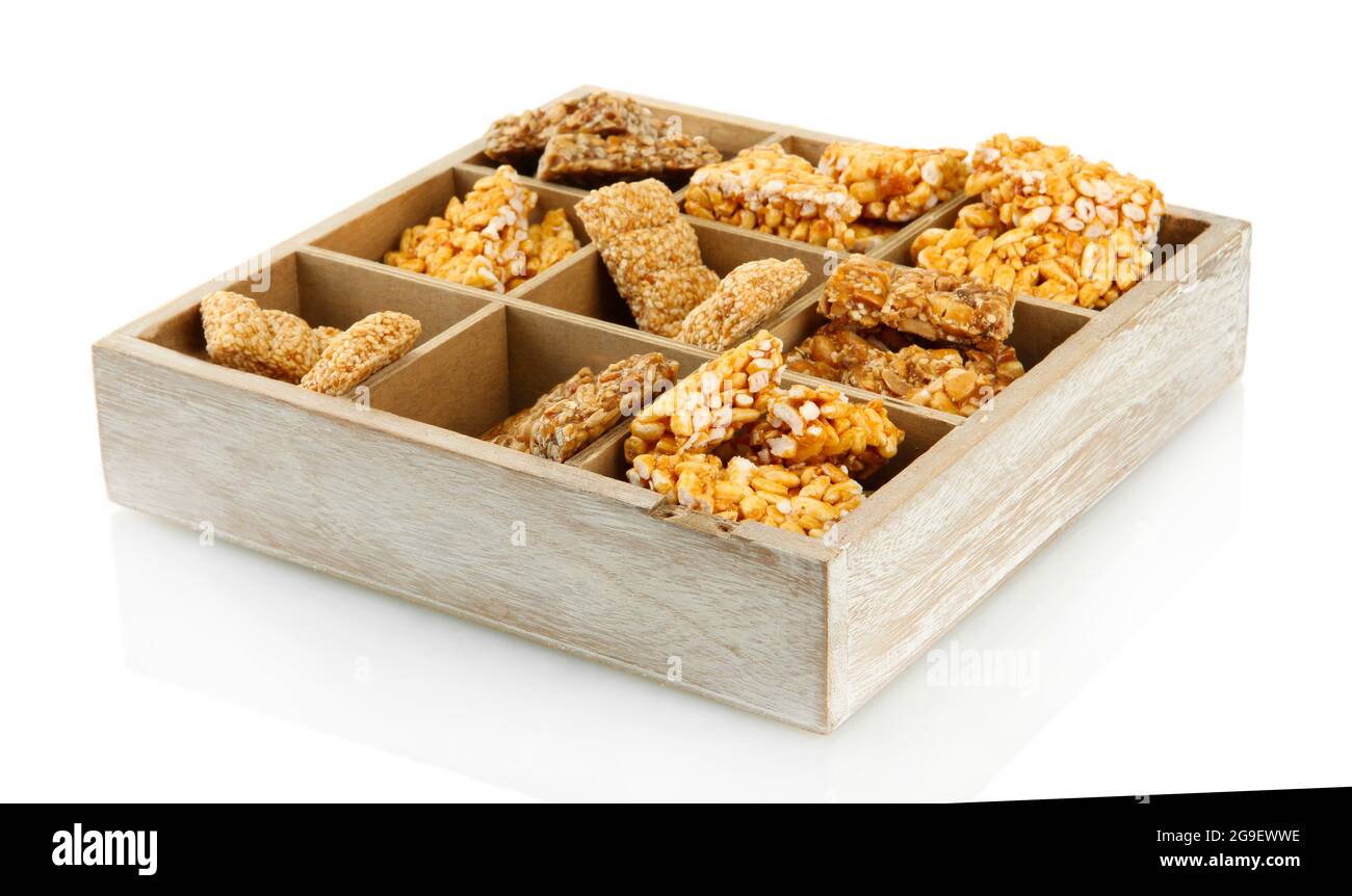 tasty sweets (kozinaki)in wooden crate, isolated on white Stock Photo ...
