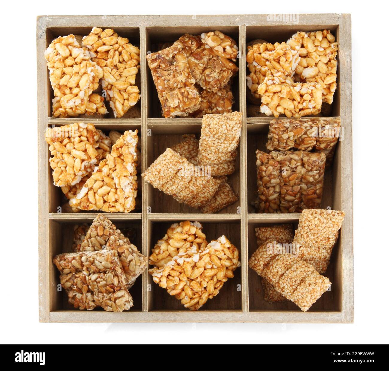 tasty sweets (kozinaki)in wooden crate, isolated on white Stock Photo ...