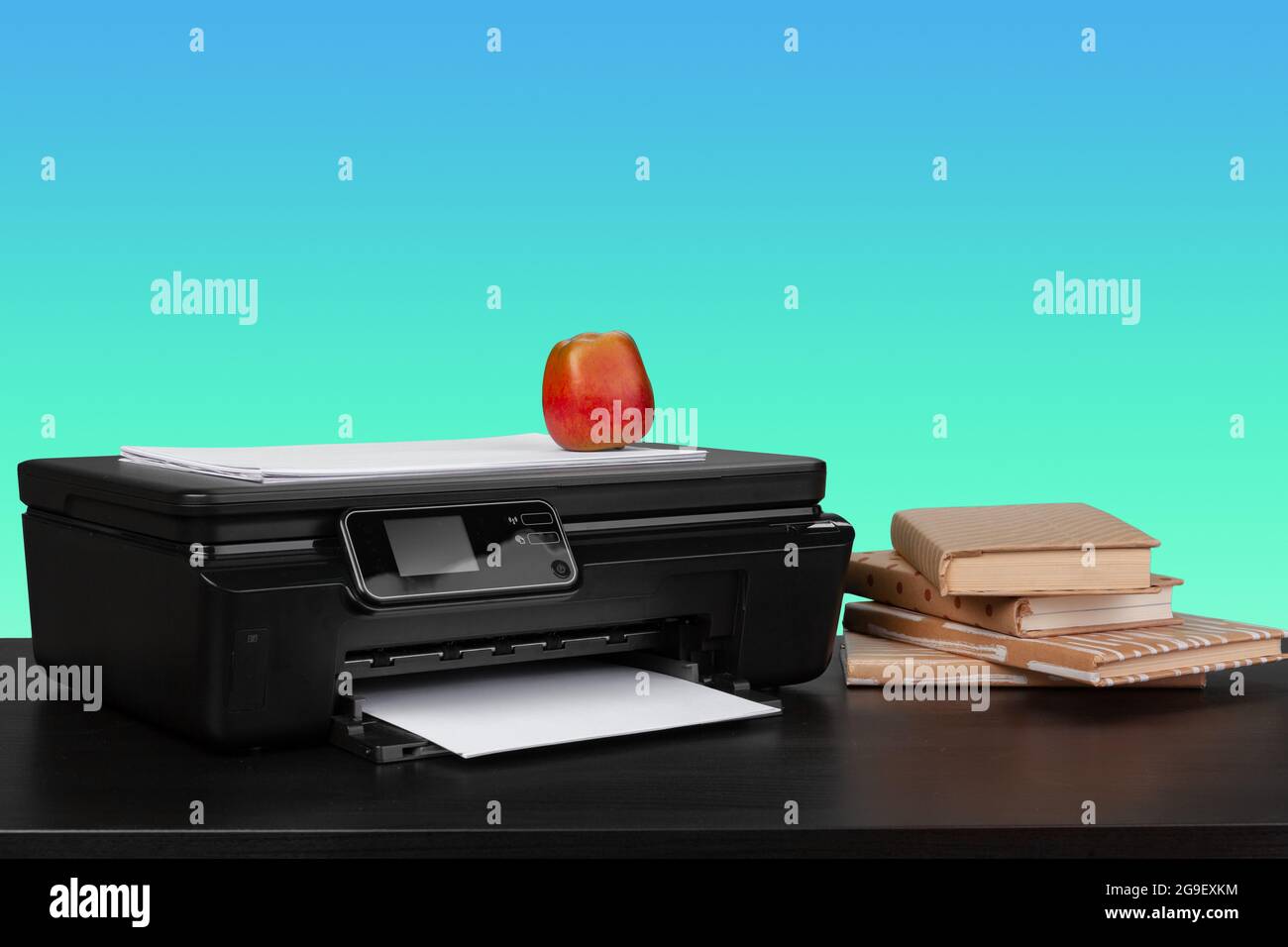 Home laser printer on desk against green background Stock Photo - Alamy