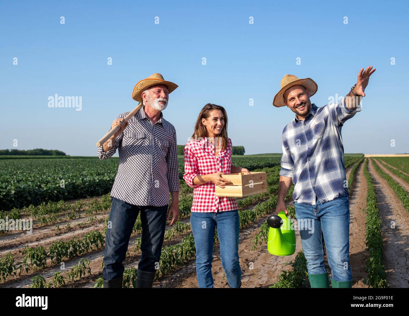 Young male farmer holding watering can pointing showing with hand ...