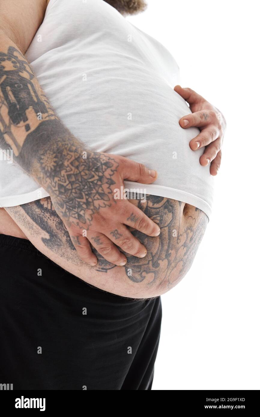 Happy fat man with big belly and tattoes in sports wear is holding his ...