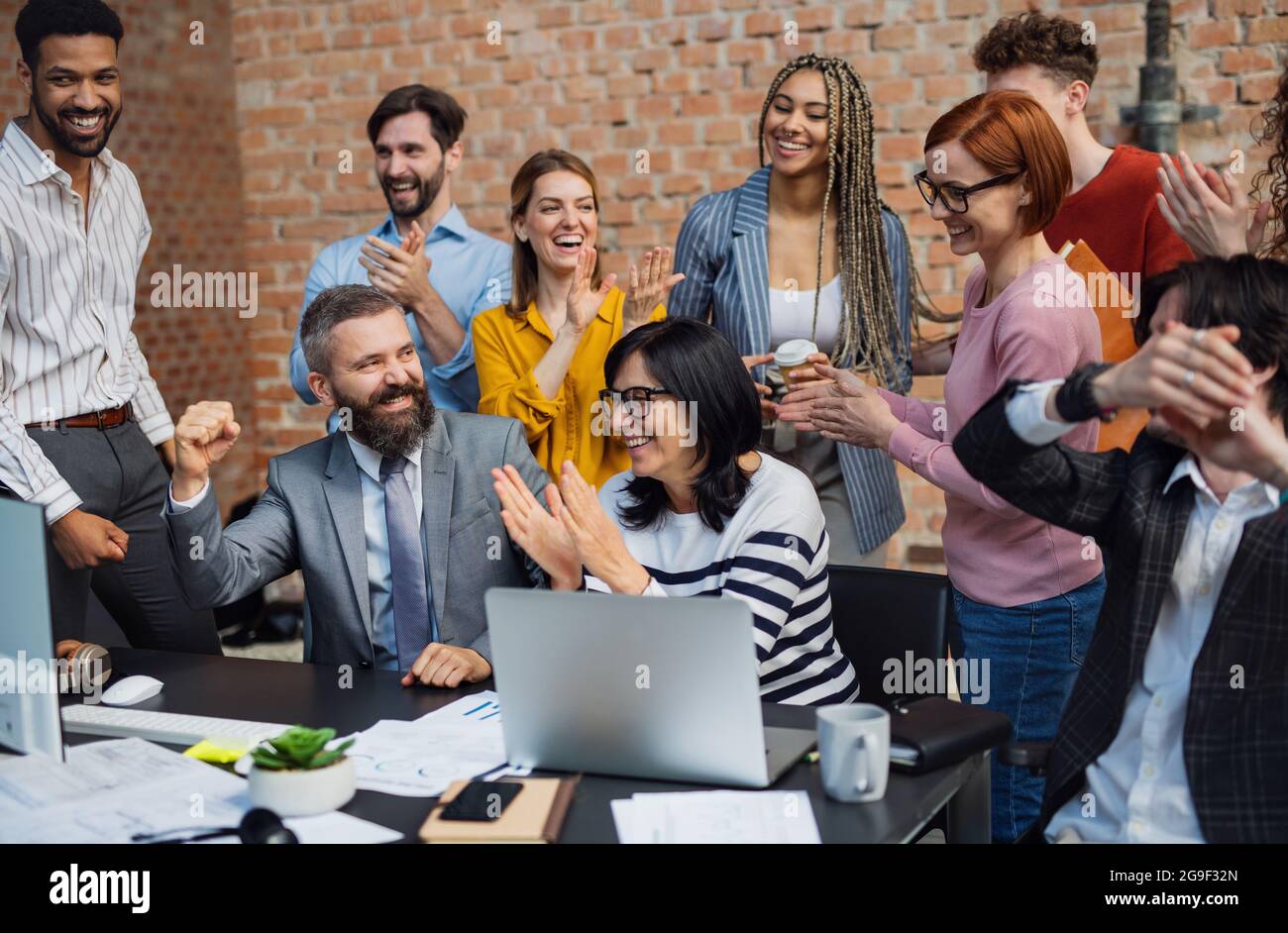 Group of excited entrepreneurs working on project indoors in office ...