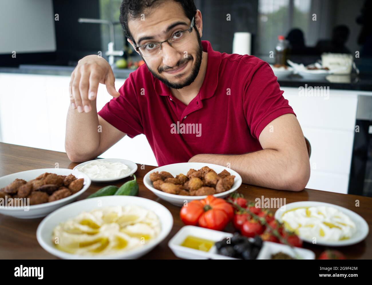 Middle Eastern young man sitting and eating traditional food alone ...