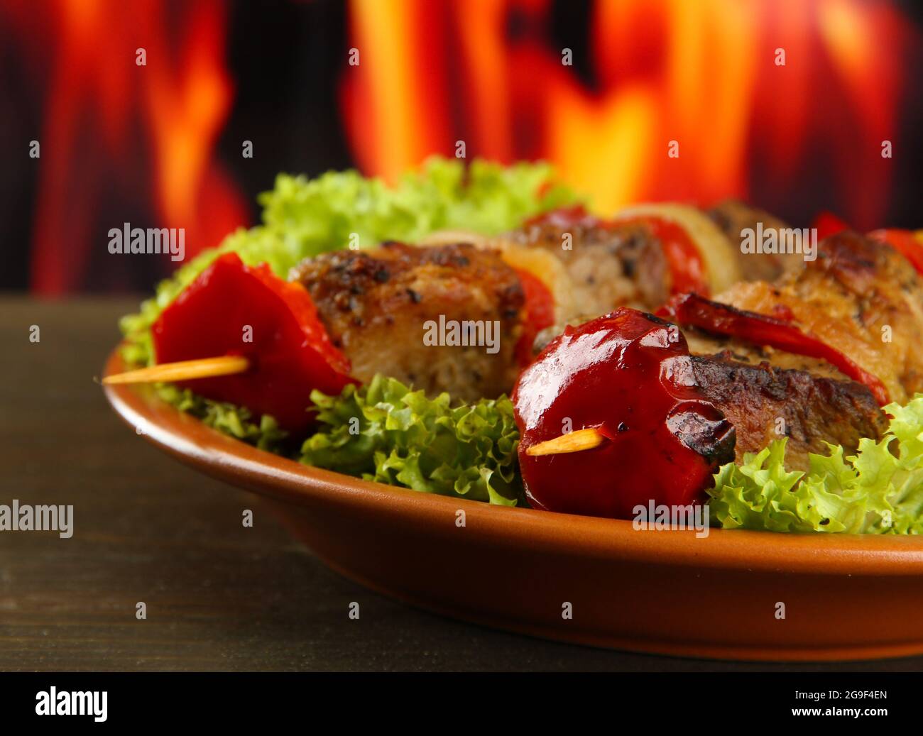 tasty grilled meat and vegetables on plate, on fire background Stock ...