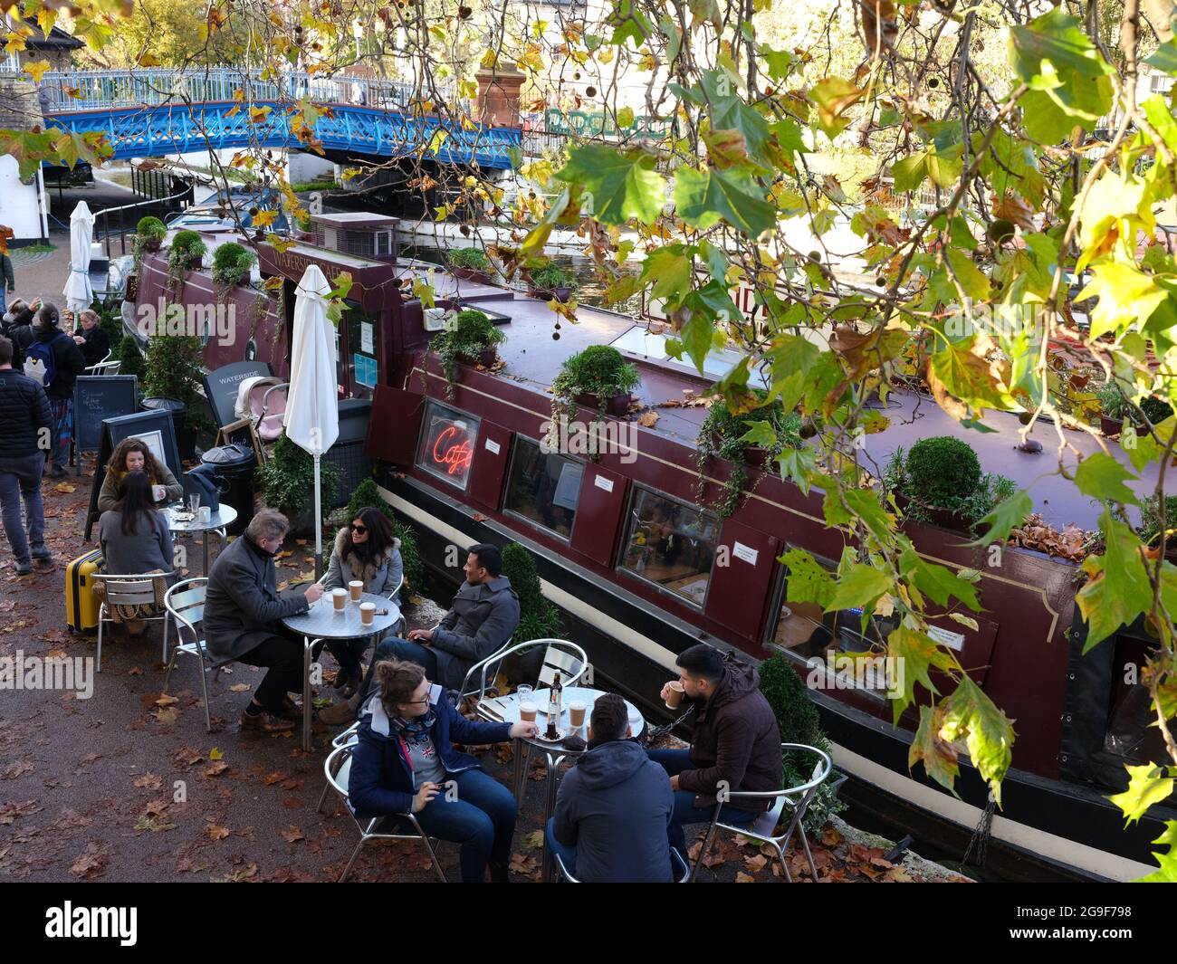Customers drink coffee and consume refreshments outside a narrow boat ...