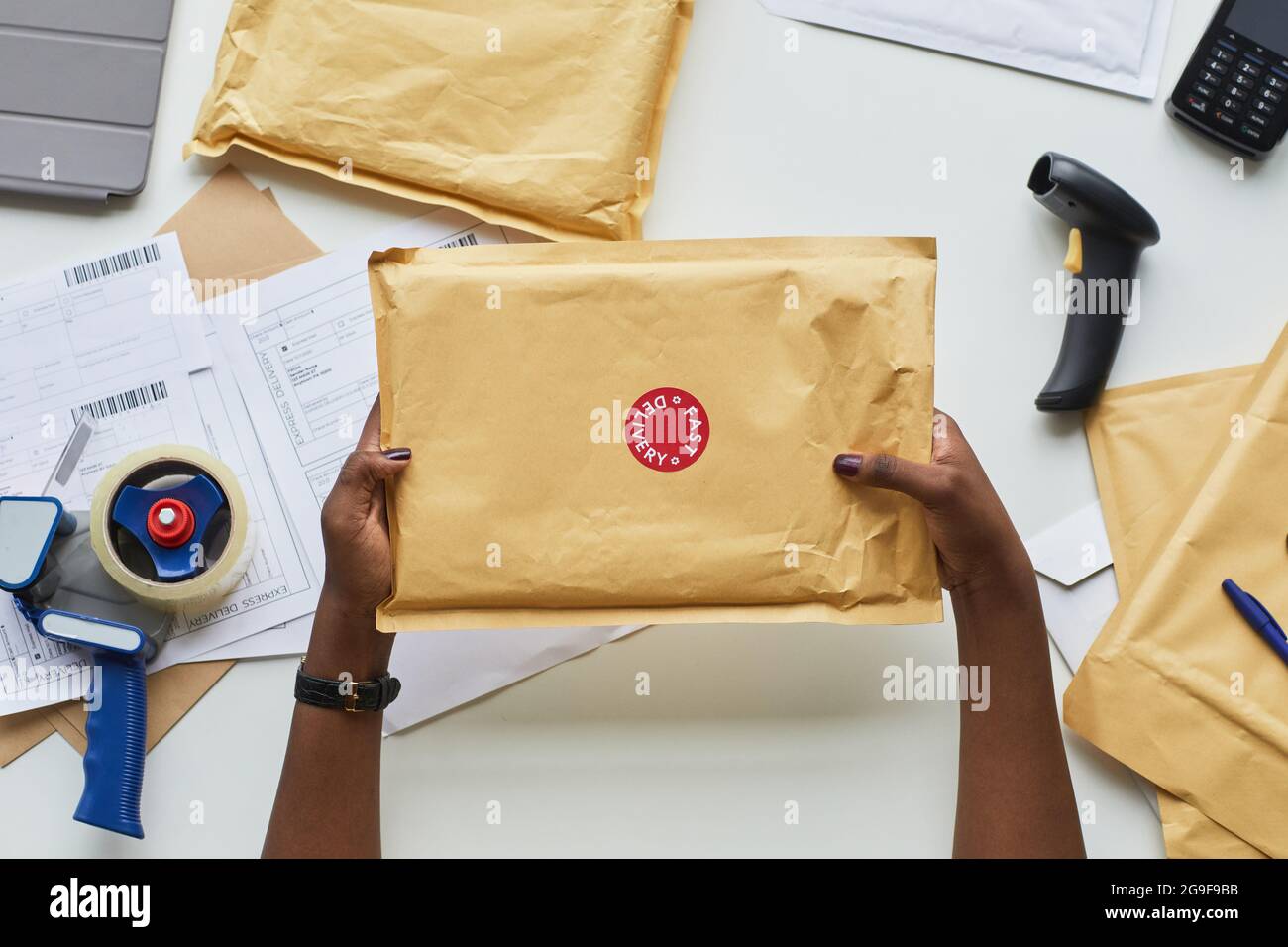 Top down view at female hands holding parcel over workplace at delivery ...