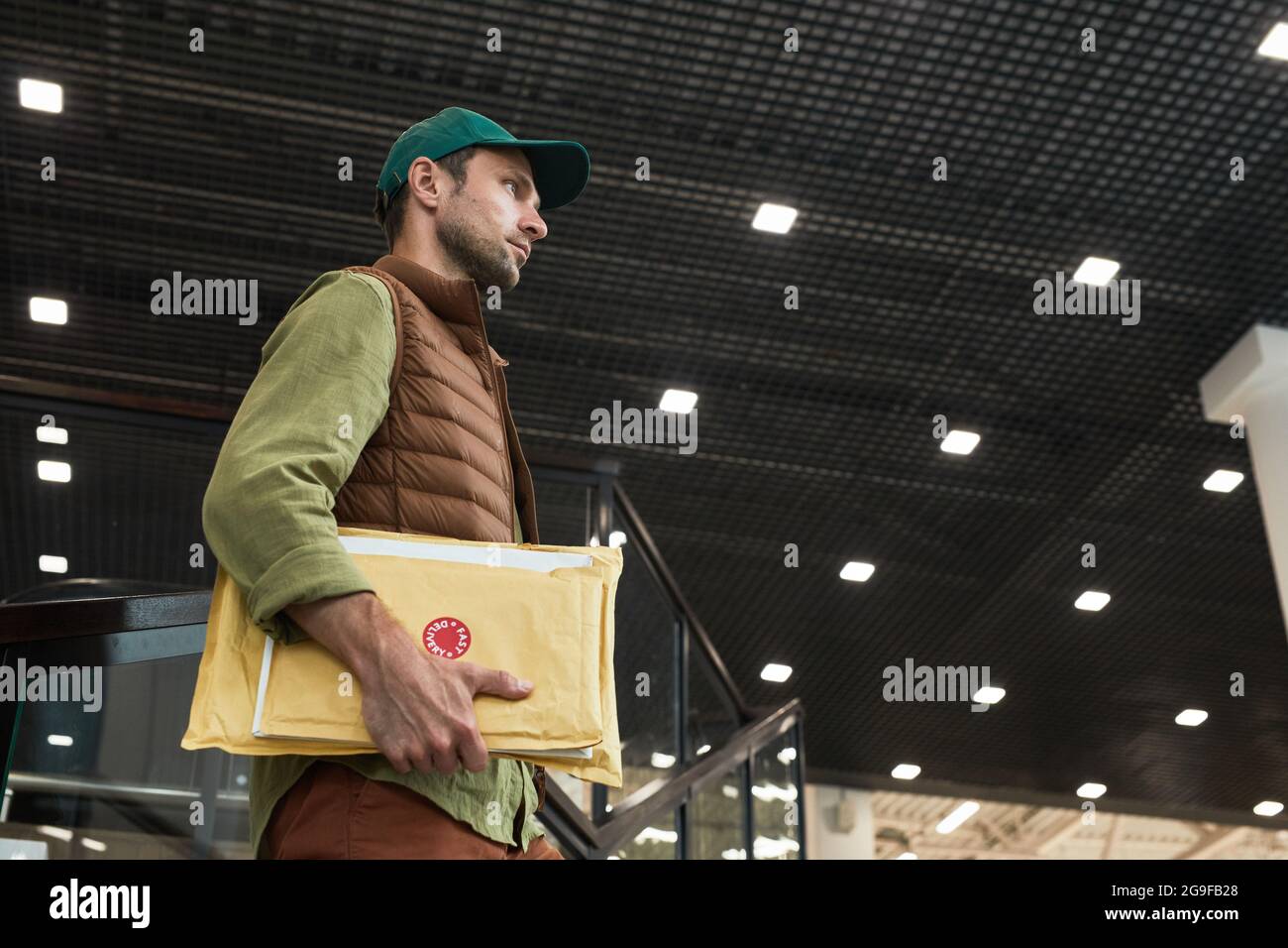Side view portrait of delivery man holding parcels while entering ...