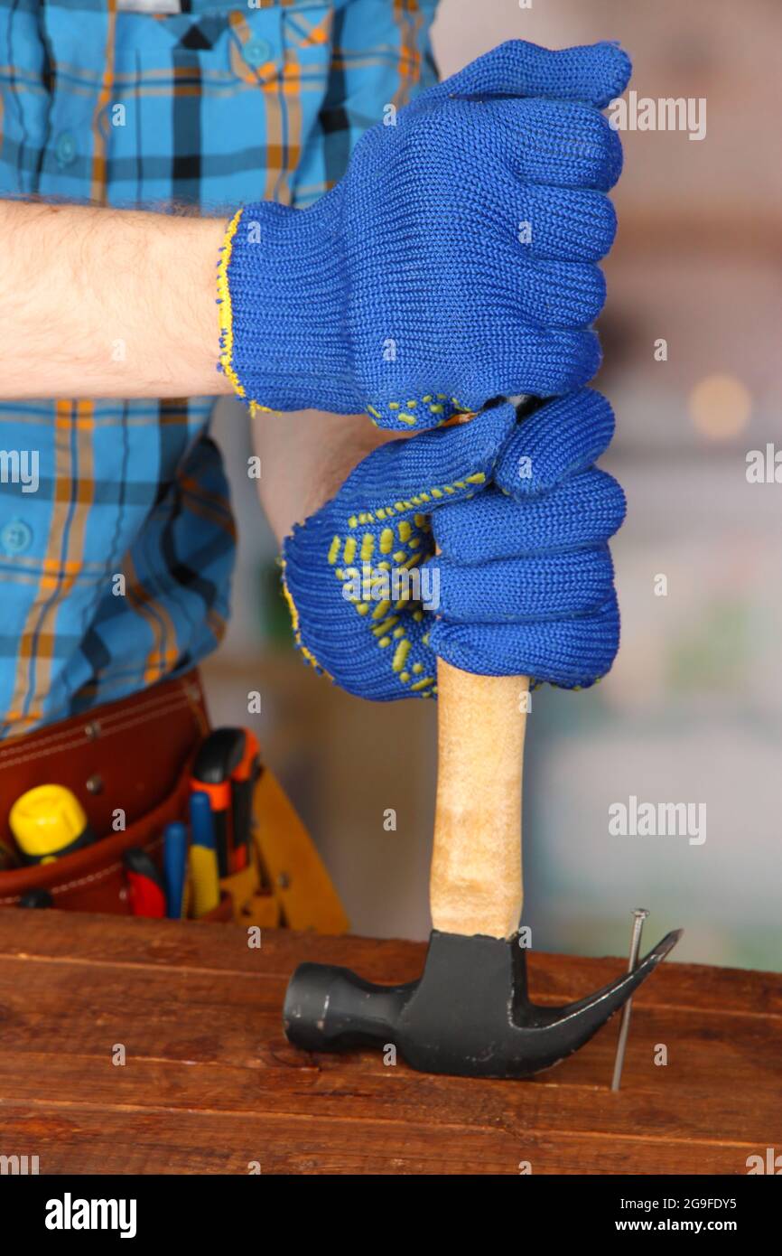 Worker pulling nail from wood Stock Photo - Alamy