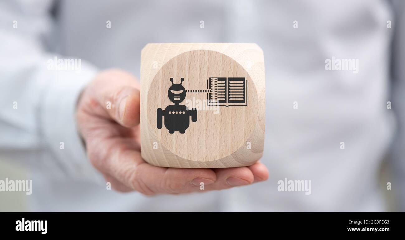 Hand holding a wooden cube with symbol of machine learning concept ...