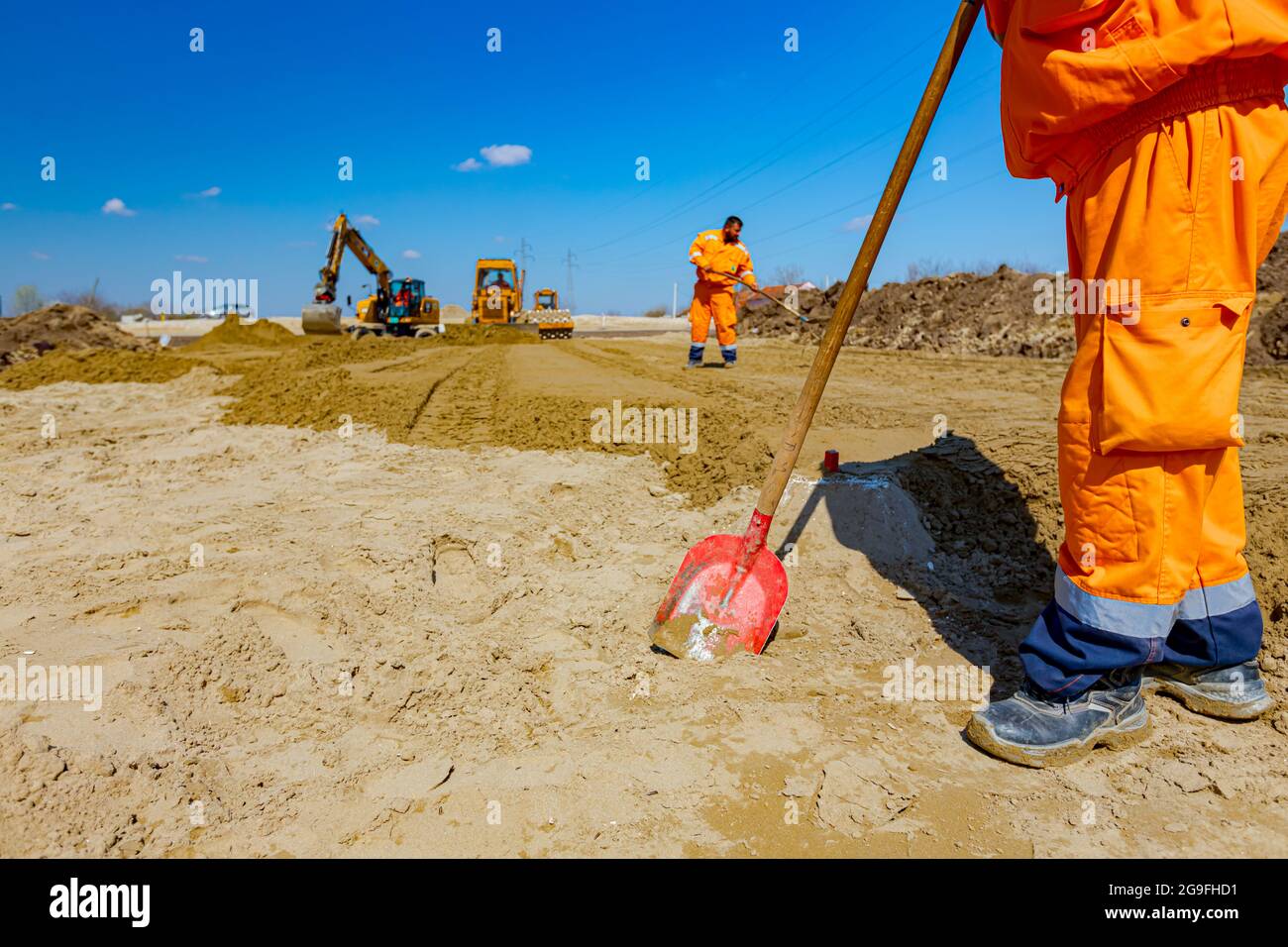 View over roller with spikes on bulldozer and excavators are leveling ...