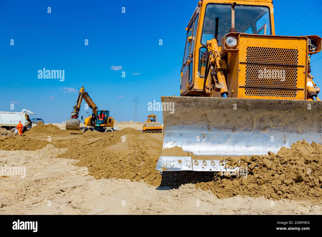 Earthmover with caterpillar is moving earth outdoors Stock Photo - Alamy