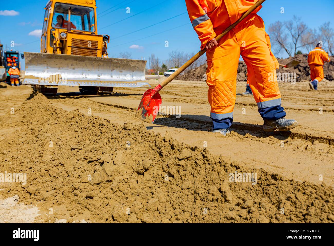 View on bulldozer and excavator that are leveling sand for road ...