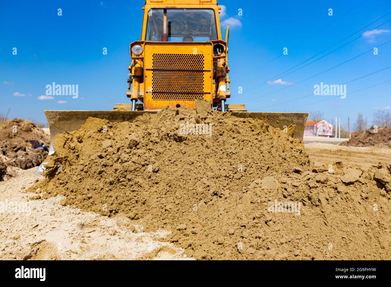 Earthmover with caterpillar is moving earth outdoors Stock Photo - Alamy