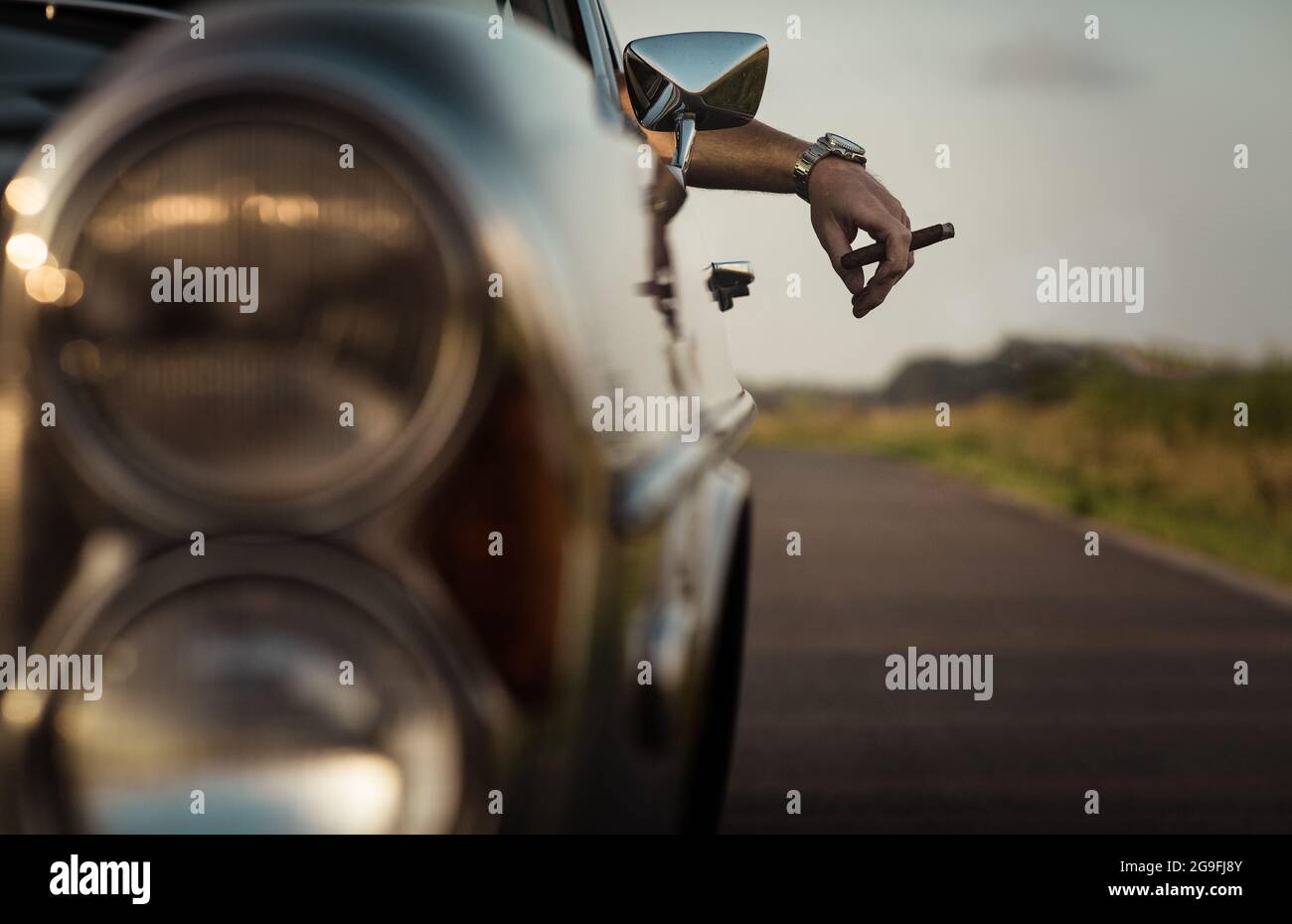 Selective focus shot of a male smoking a cigar in a car Stock Photo - Alamy
