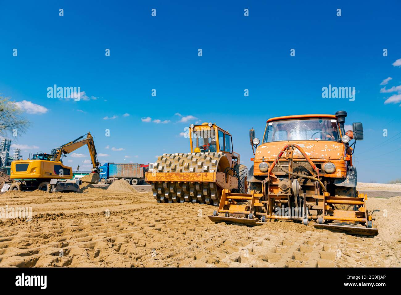 Road roller with spikes and truck with mounted plate vibration ...