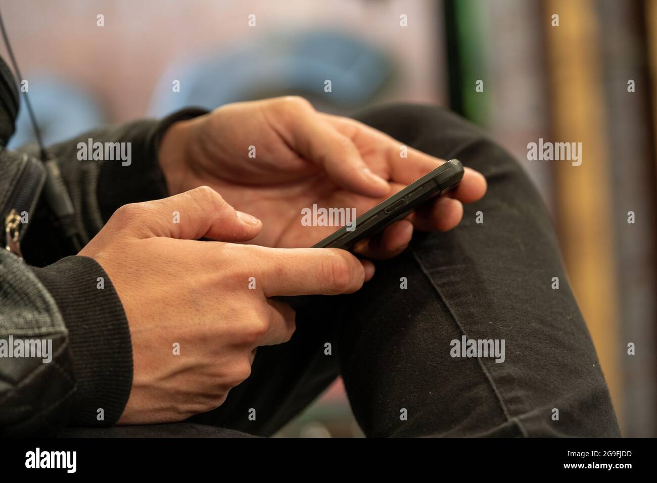 Person sitting down and texting on the phone Stock Photo - Alamy
