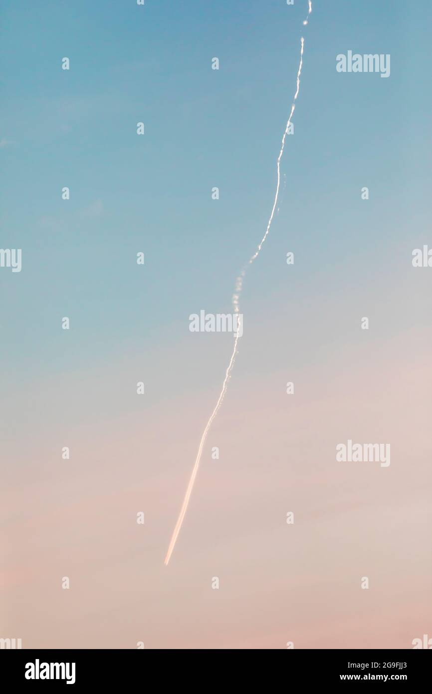 Contrail from an airplane in a sunset sky. Vertical photography Stock ...
