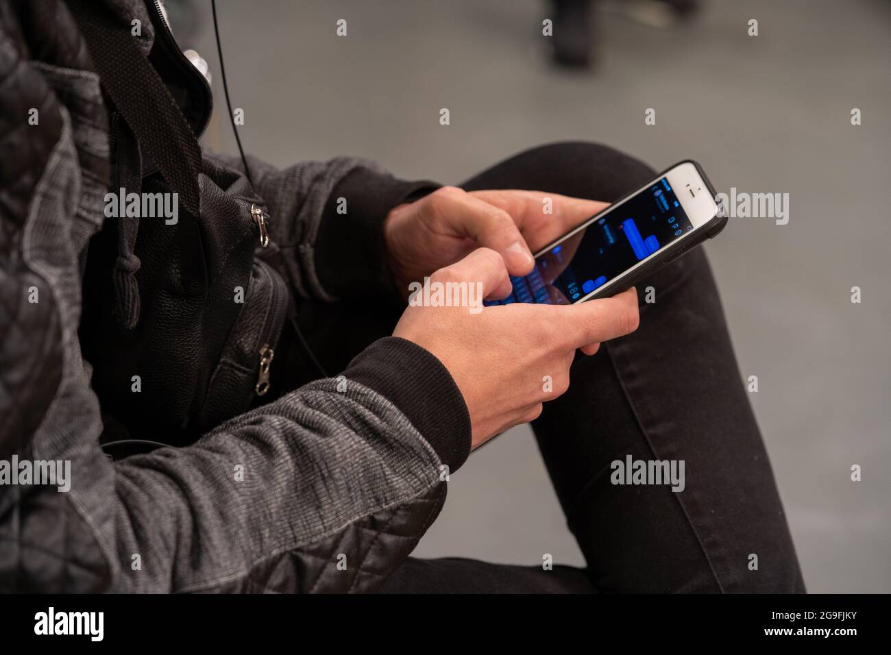 Person sitting down and texting on the phone Stock Photo - Alamy