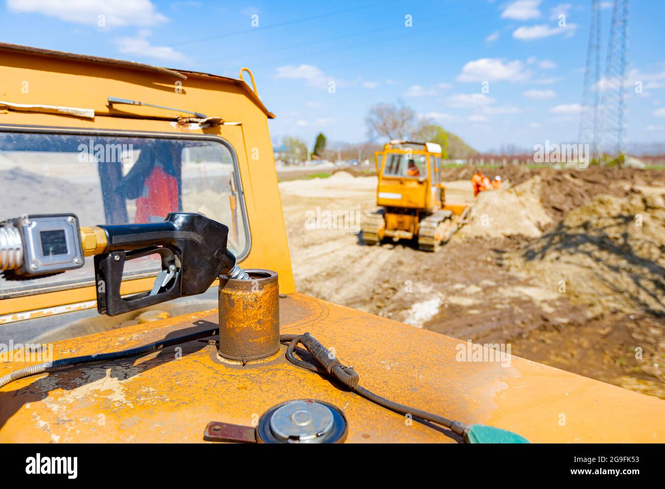 Fuel pump gun inserted in the reservoir of construction machine, pour ...