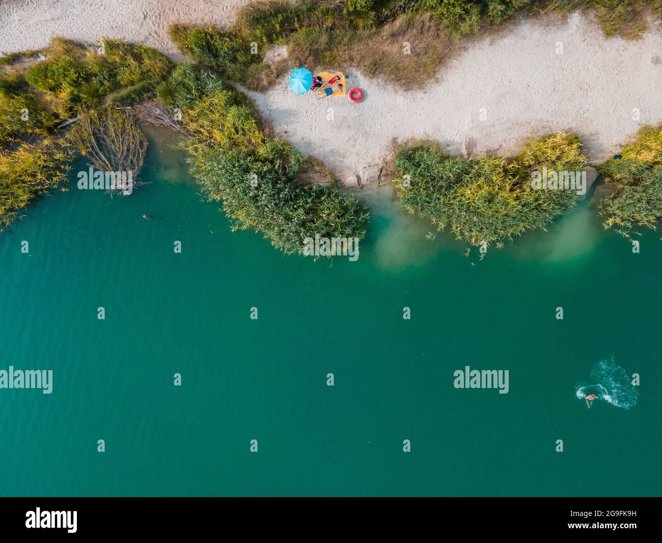 couple laying on blanket sunbathing at sandy beach blue azure water ...