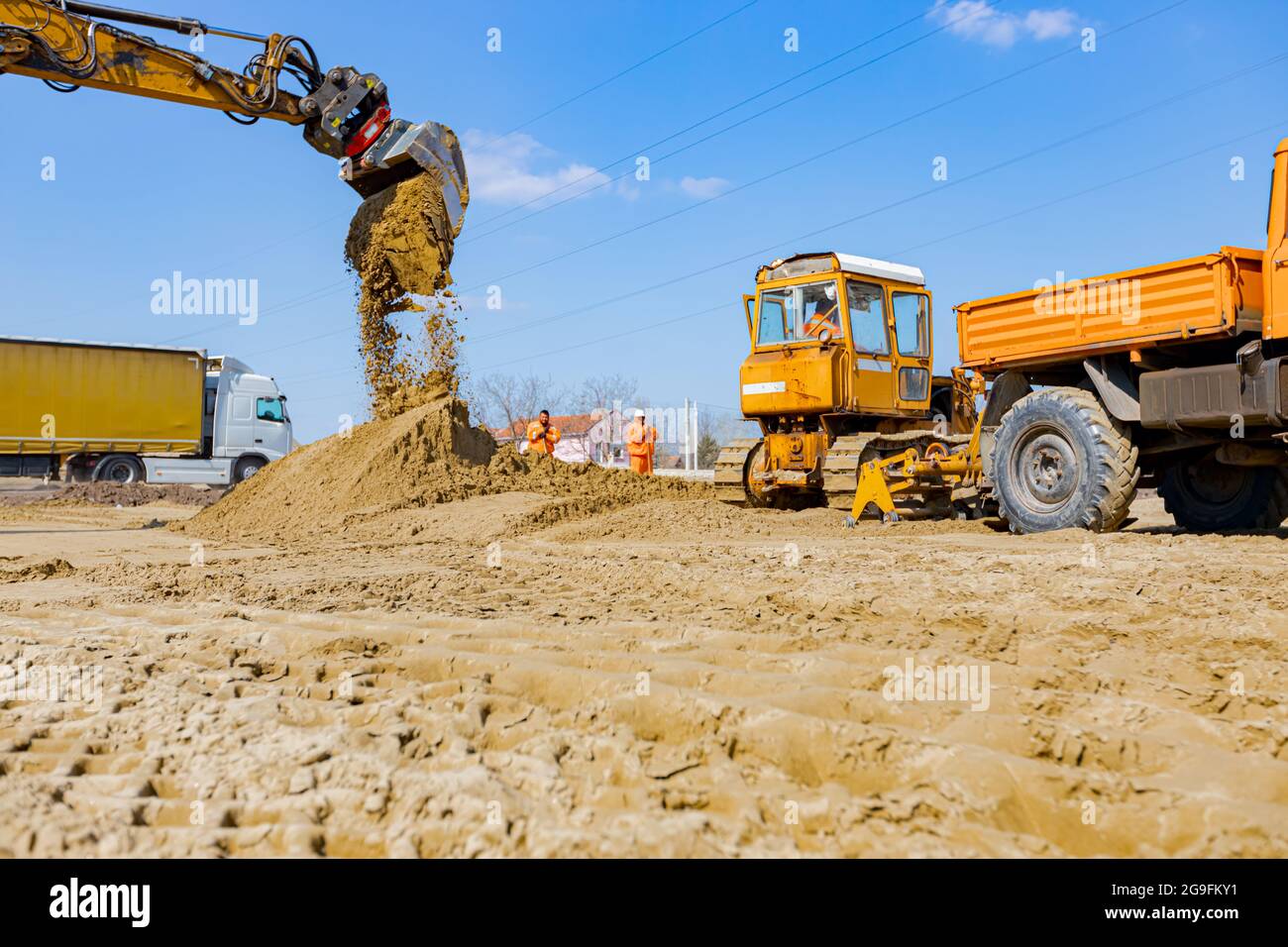 View on excavator and truck with mounted plate vibration compactor, as ...
