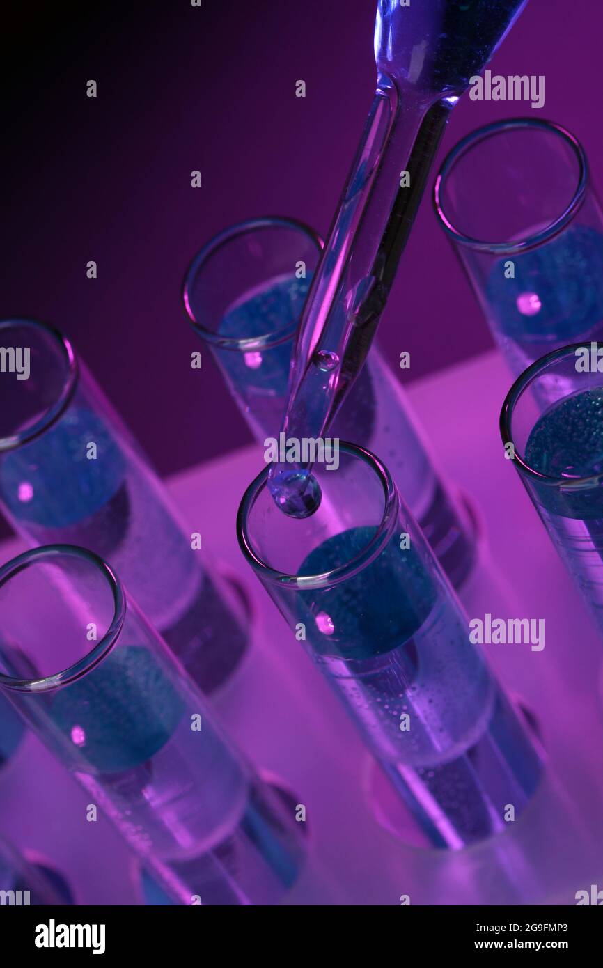 test-tubes with liquid on purple background Stock Photo - Alamy
