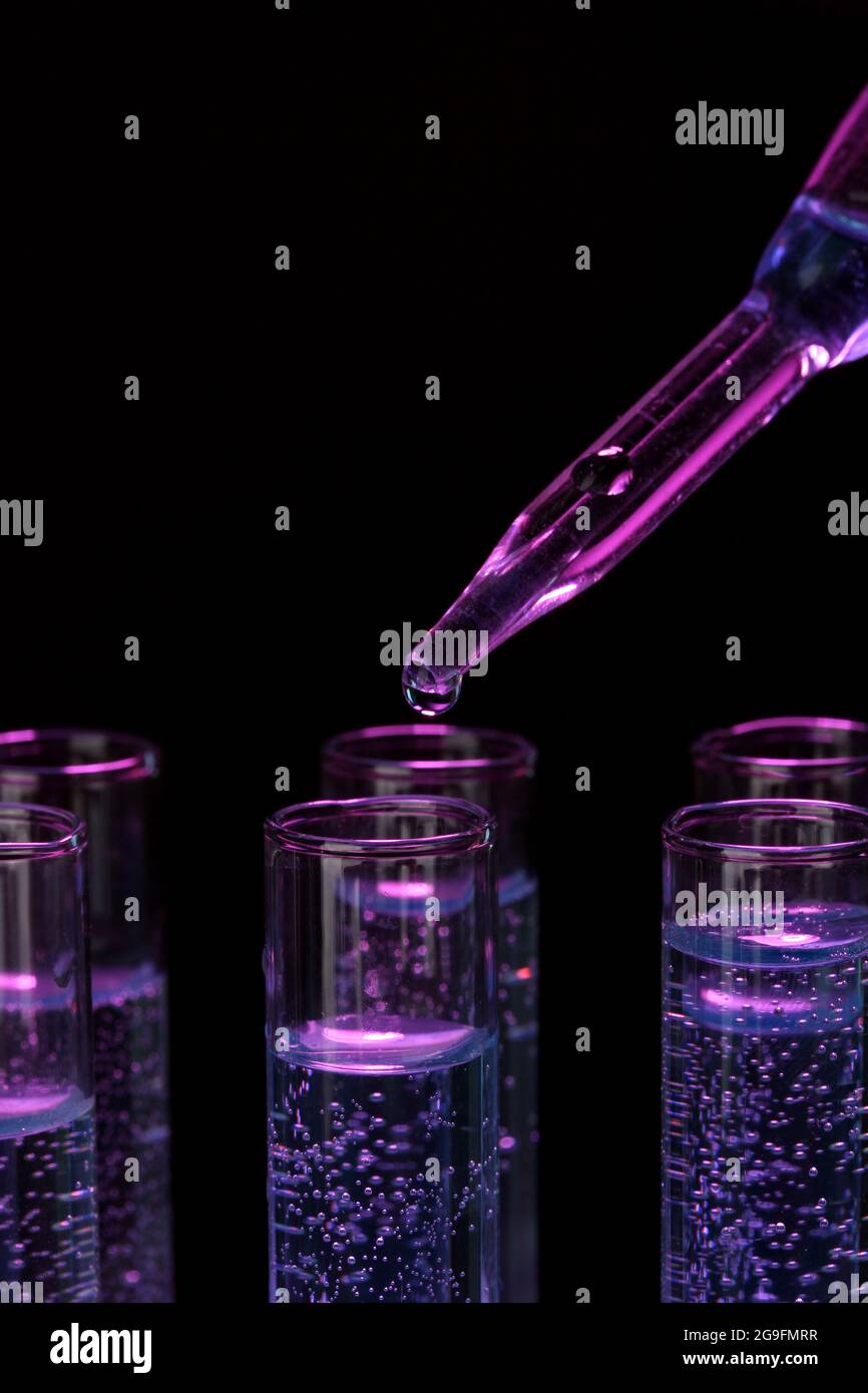 test-tubes with liquid on black background Stock Photo - Alamy