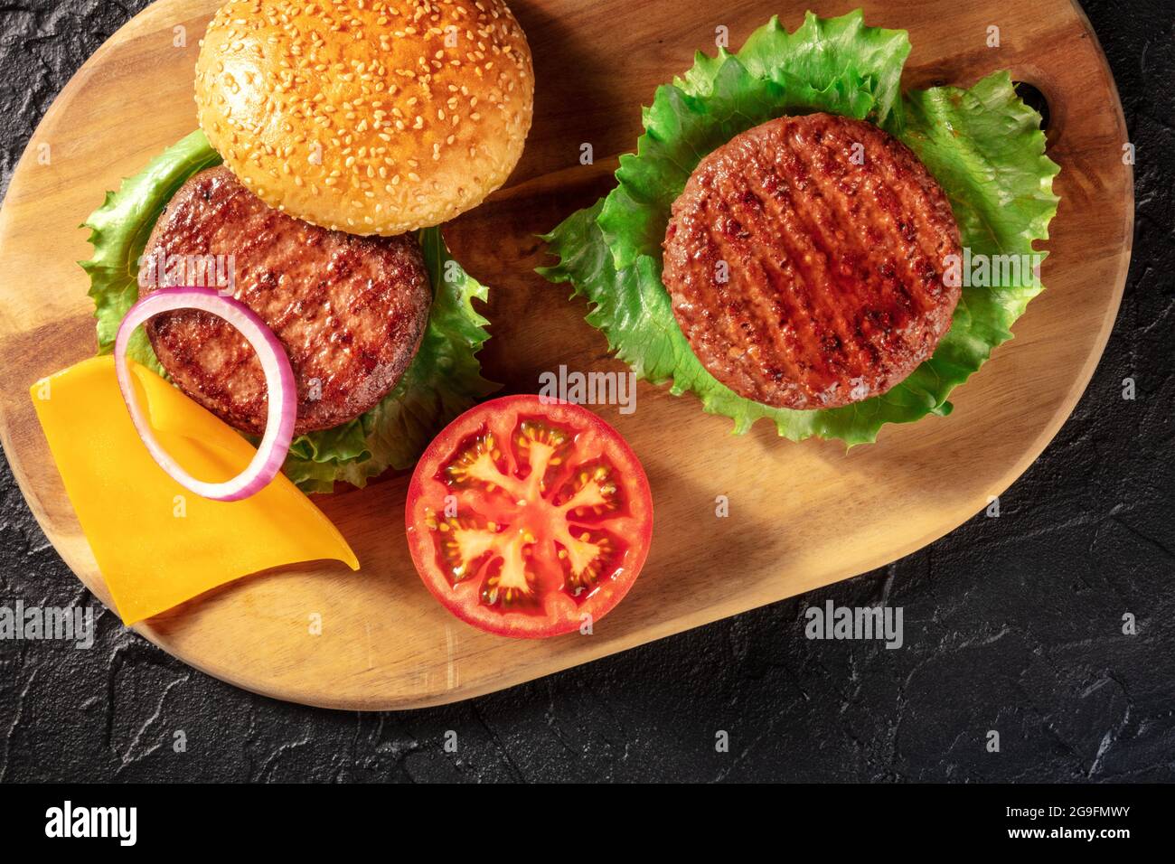 Burger ingredients on a black background. Homemade hamburgers with beef ...