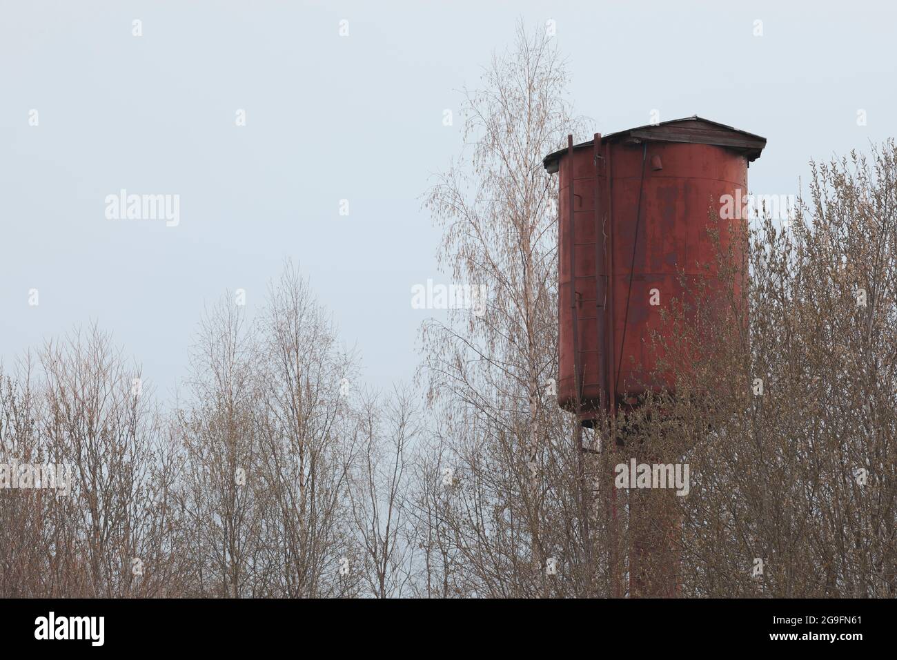 Water tower with trees and bushes with buds. Early spring Stock Photo ...
