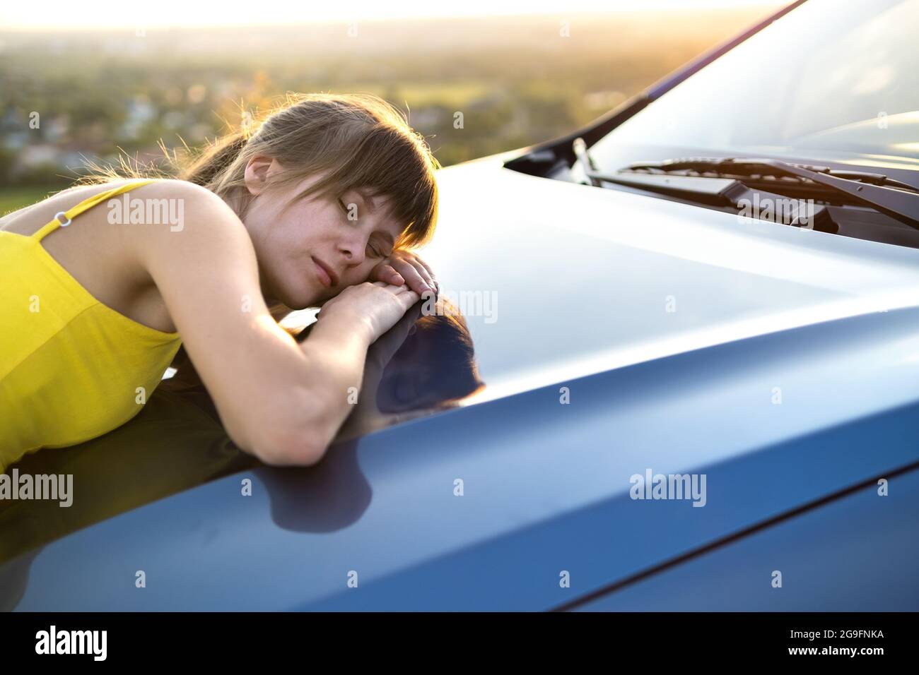 Young female driver resting near her car on warm summer evening Stock ...