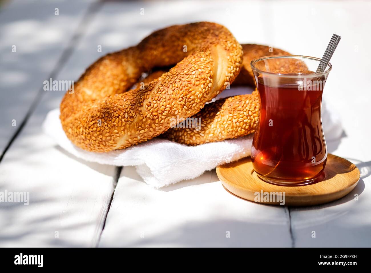 Traditional Turkish sesame bagel simit and Turkish tea on white wood ...
