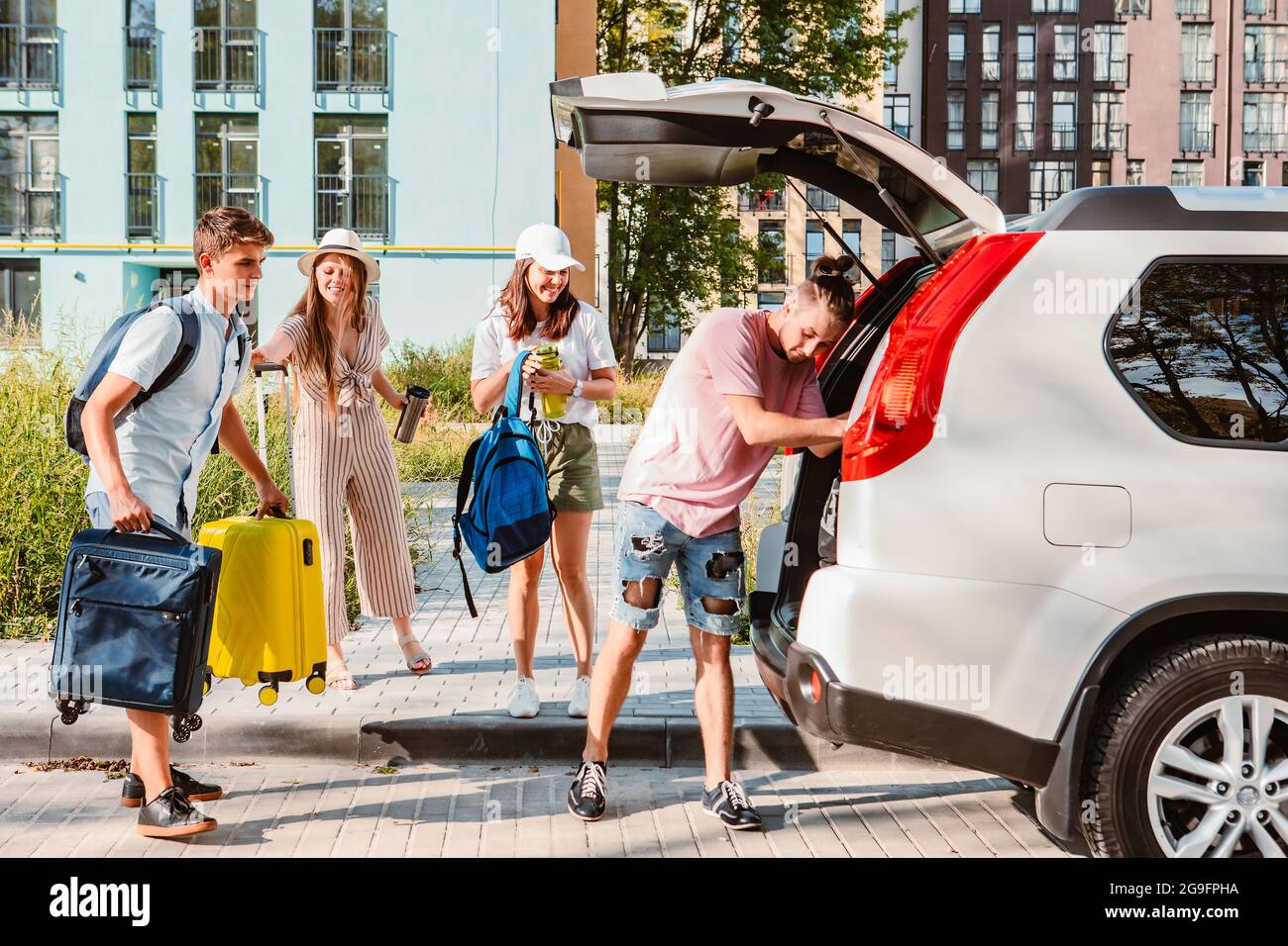 friends load car trunk with baggage. summer road trip vacation Stock ...