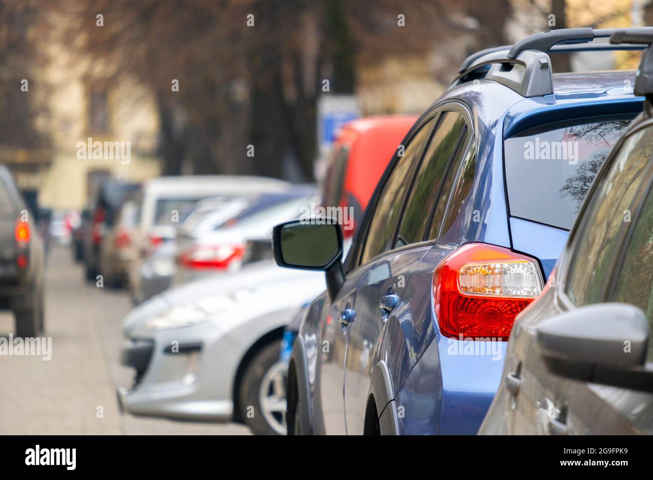 Cars parked in a row on a city street side Stock Photo - Alamy